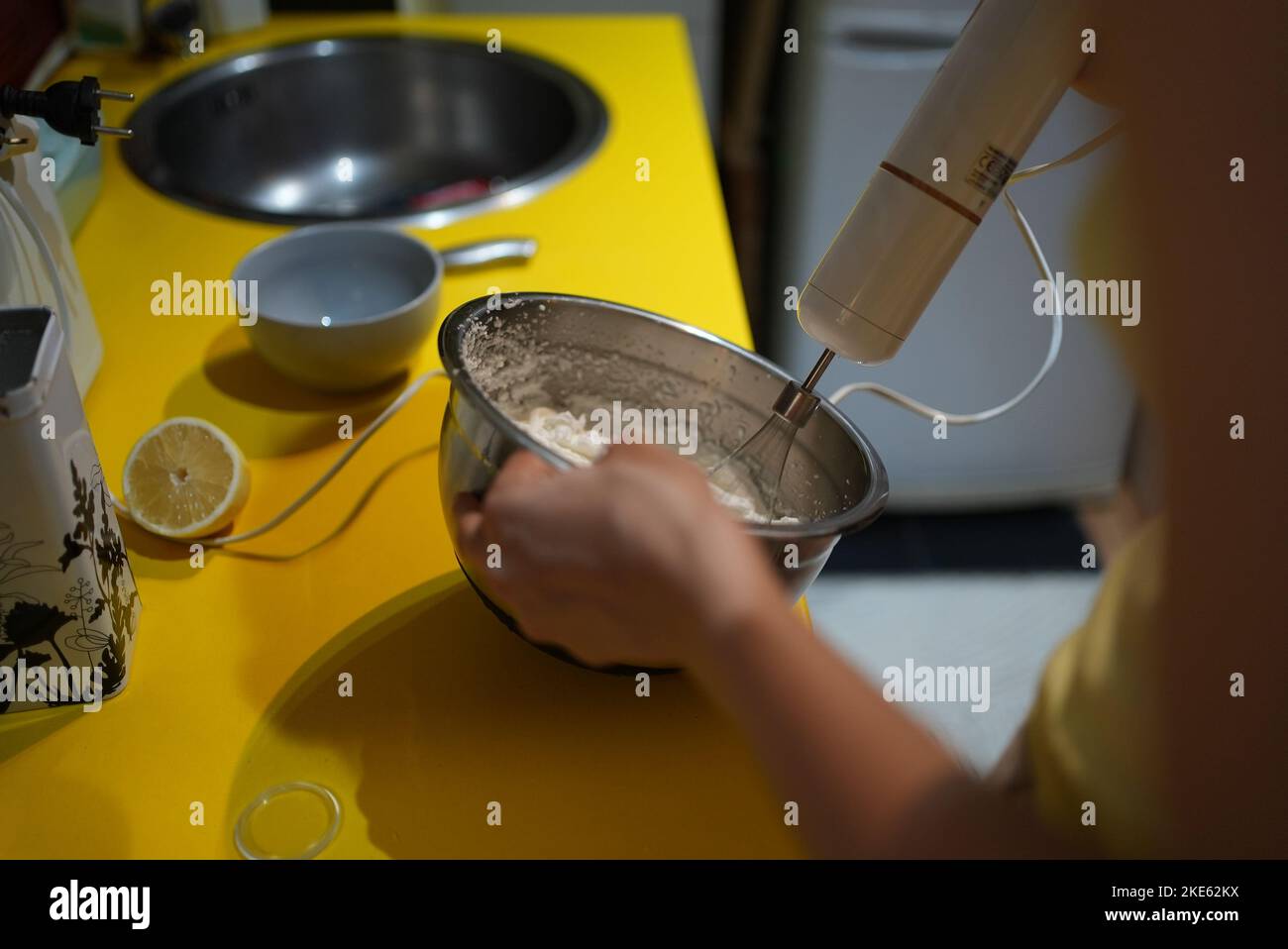 Holding a bowl while stirring ingredients with a hand mixer Stock Photo ...