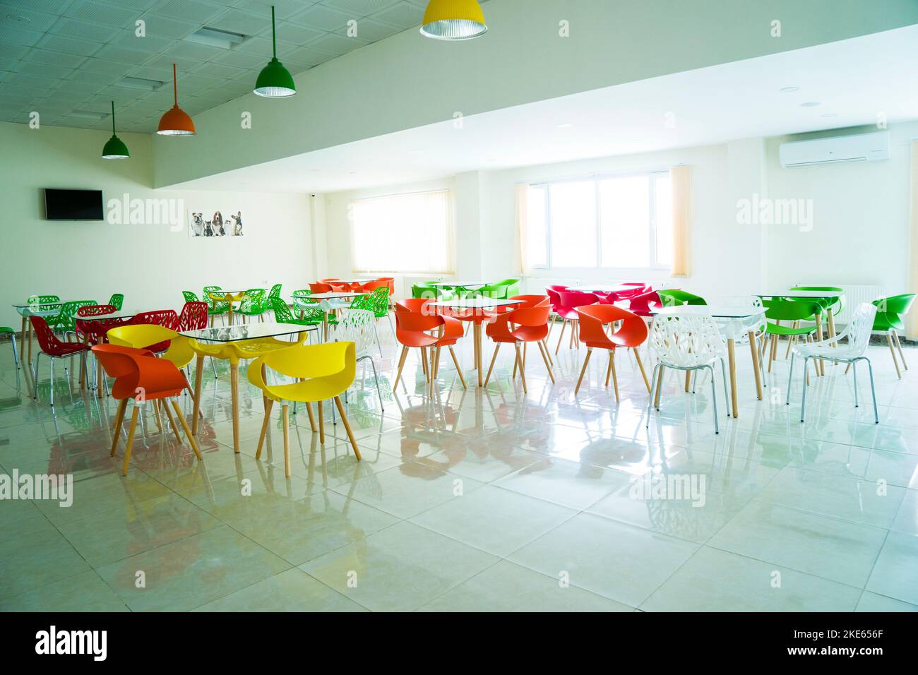 red, yellow, green plastic tables and chairs in the cafe, in the dining ...