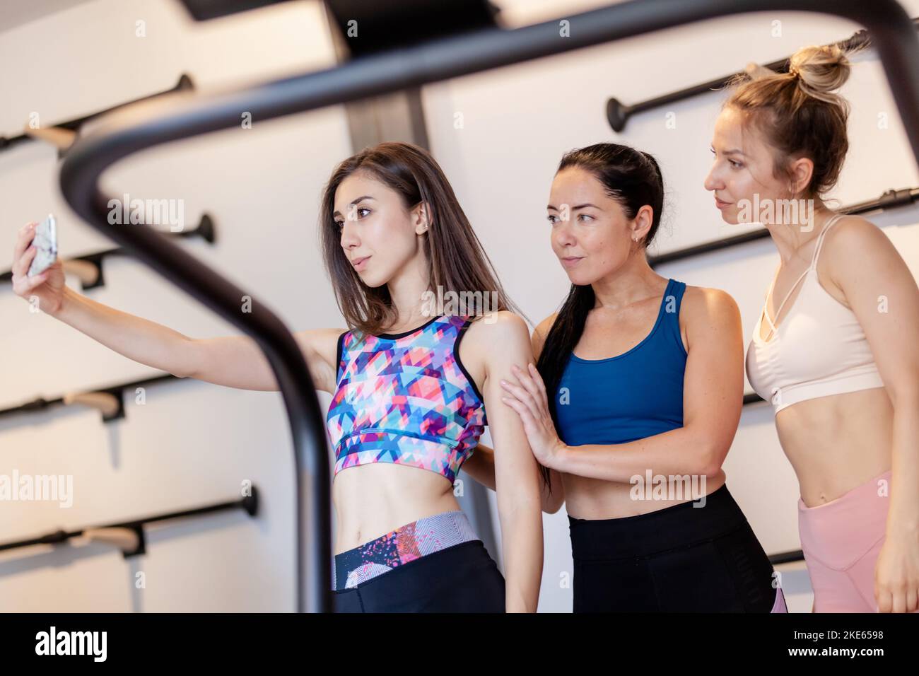 Three female friends in a fancy fitness center. Girls taking selfy and ...