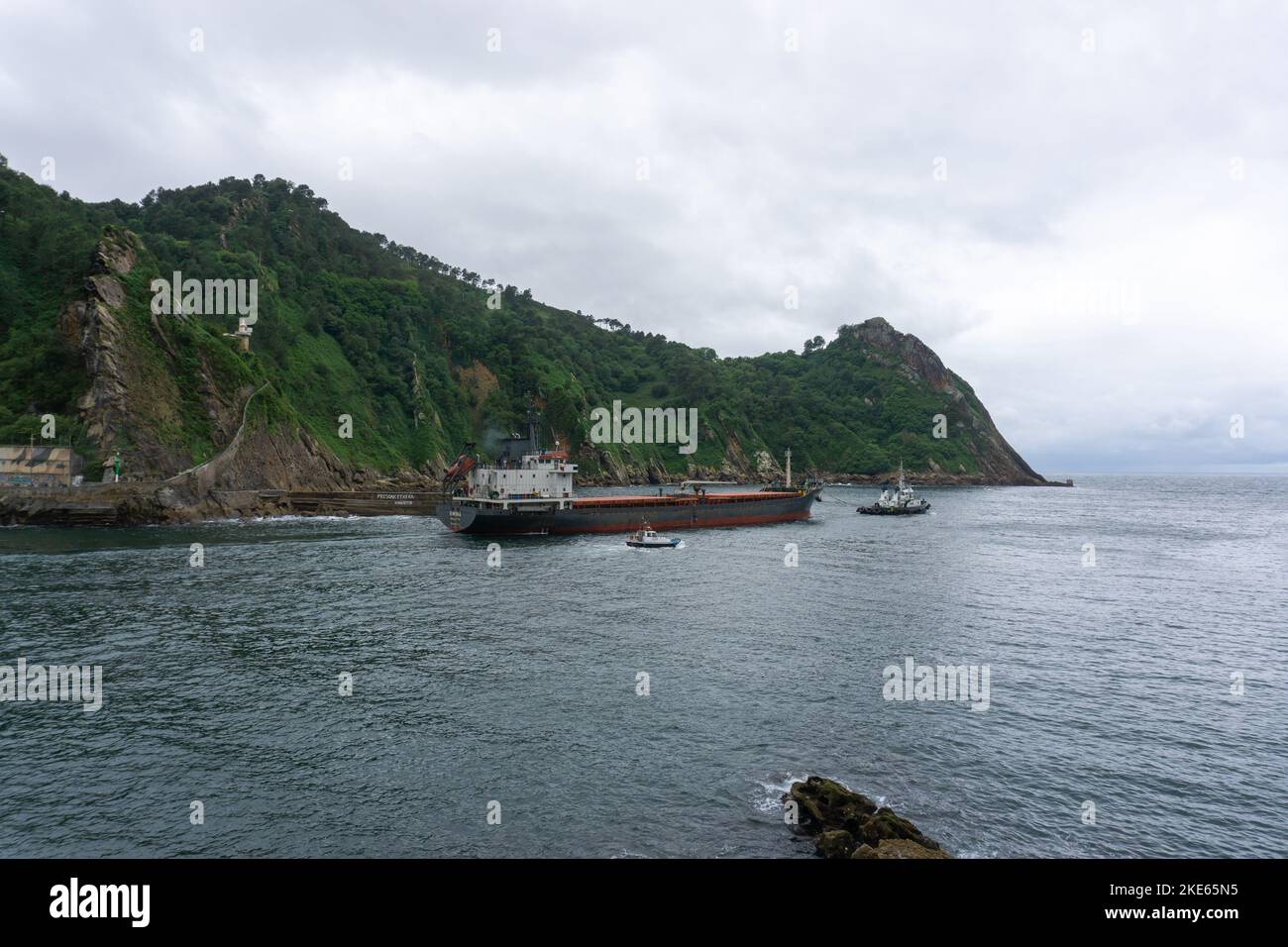 Ship being escorted out to ocean in Pasajes Spain Stock Photo - Alamy
