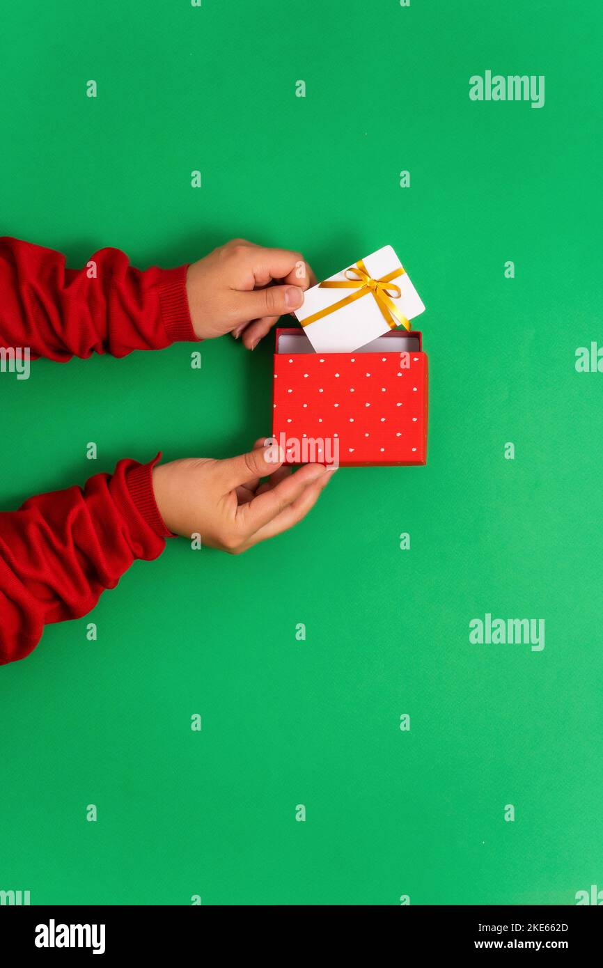 Female hands take out a bonus or gift bank card template from a gift ...