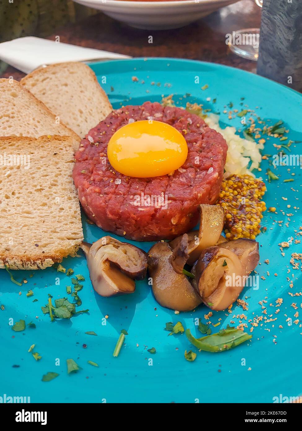 Gourmet tartar raw beef tenderloin with egg yolk and pickled boletus as ...