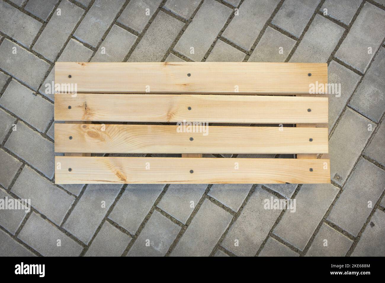 Lattice made of wooden planks on stone floor. Handicraft products Stock ...