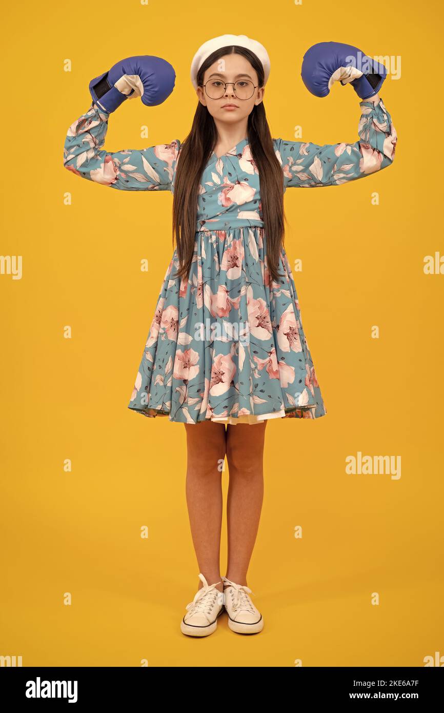 Teenage fun boxer girl in boxing gloves on yellow isolated background ...