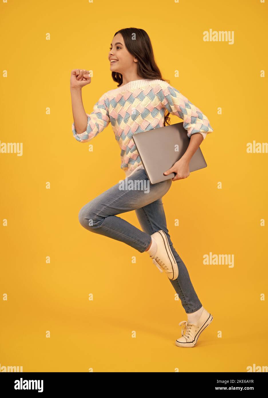 Student teenager schoolgirl with laptop on isolated background. Run and ...