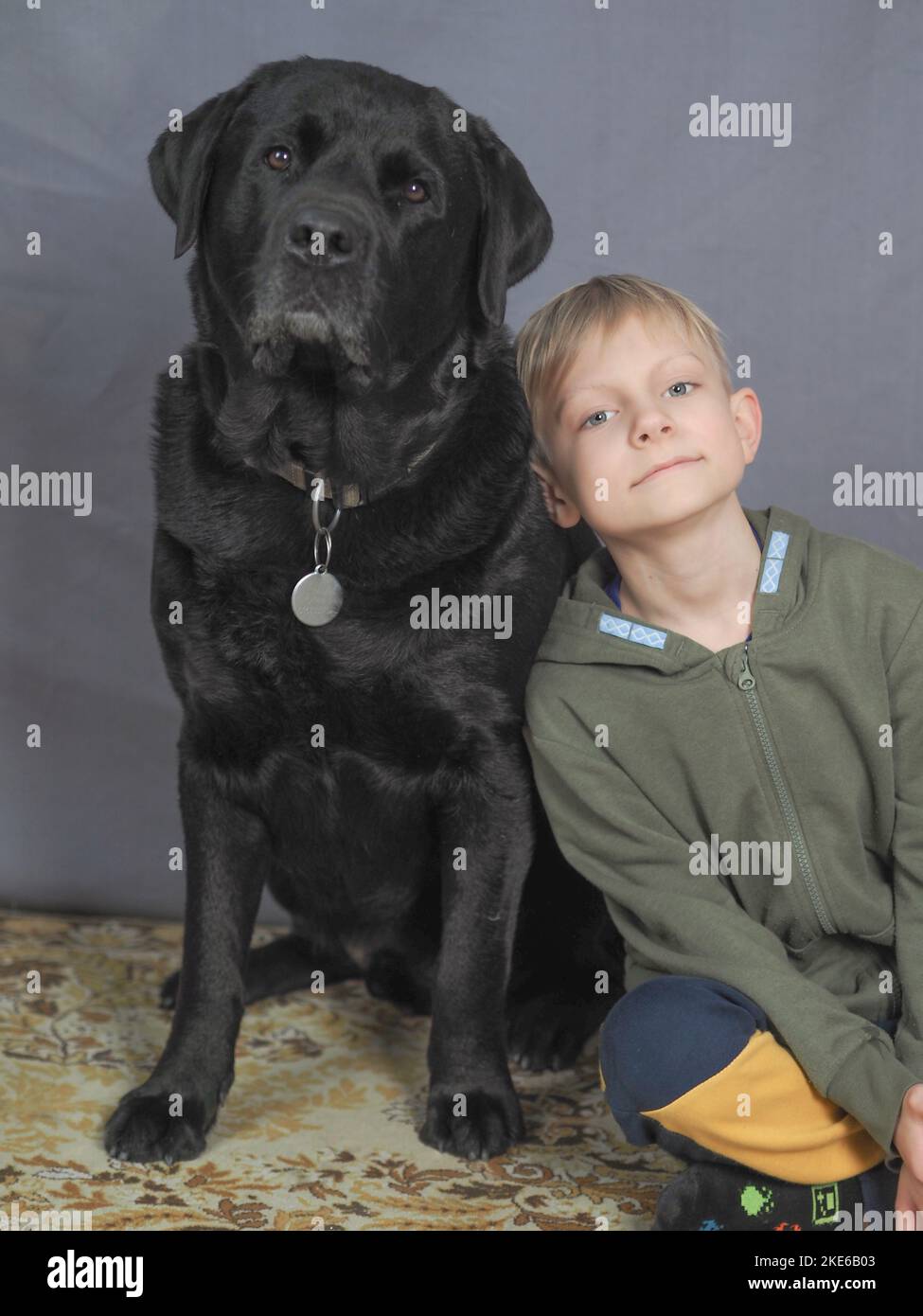 Caucasian boy with big black dog Stock Photo - Alamy