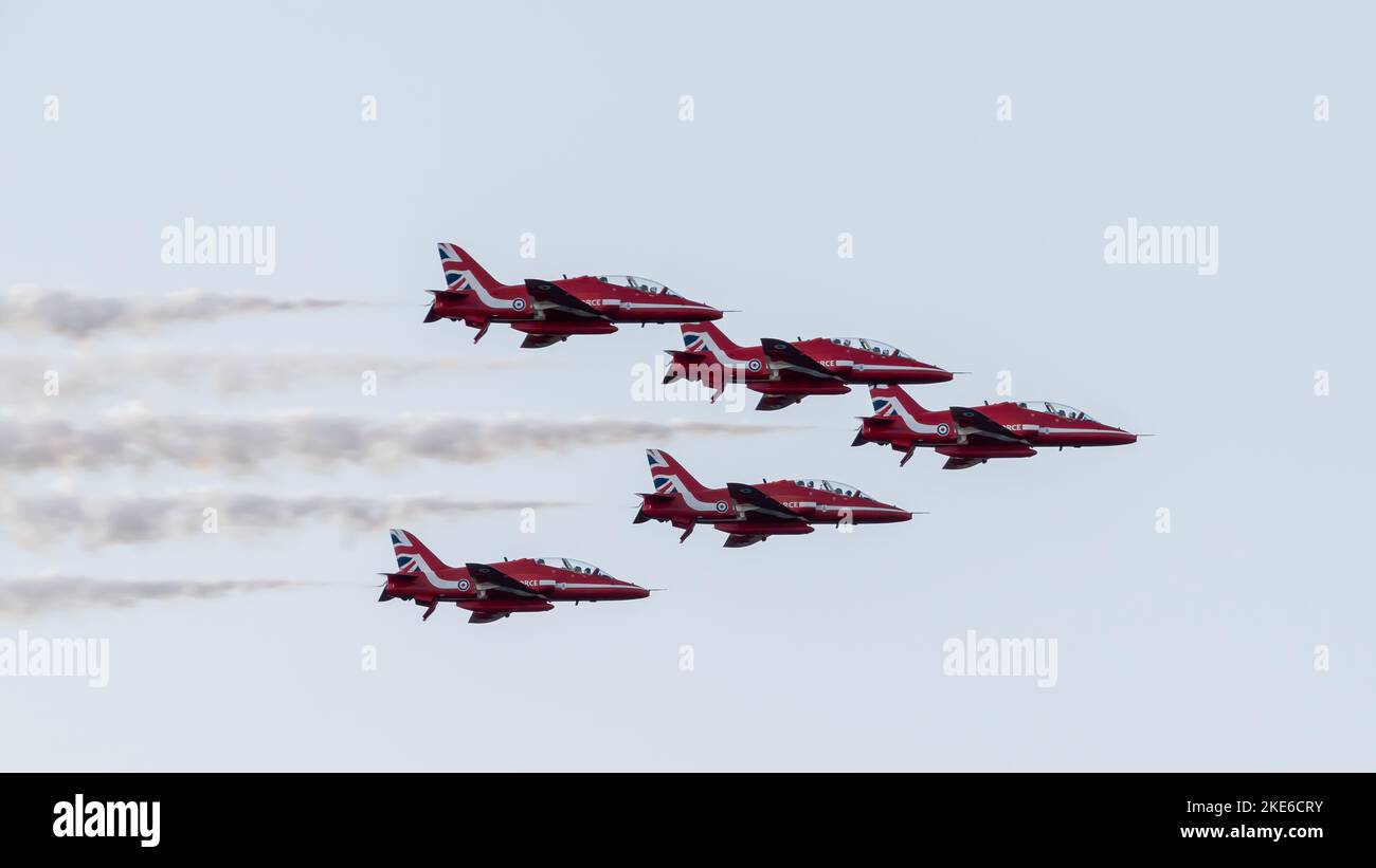 A closeup of group of red planes in formation with white arrows and ...