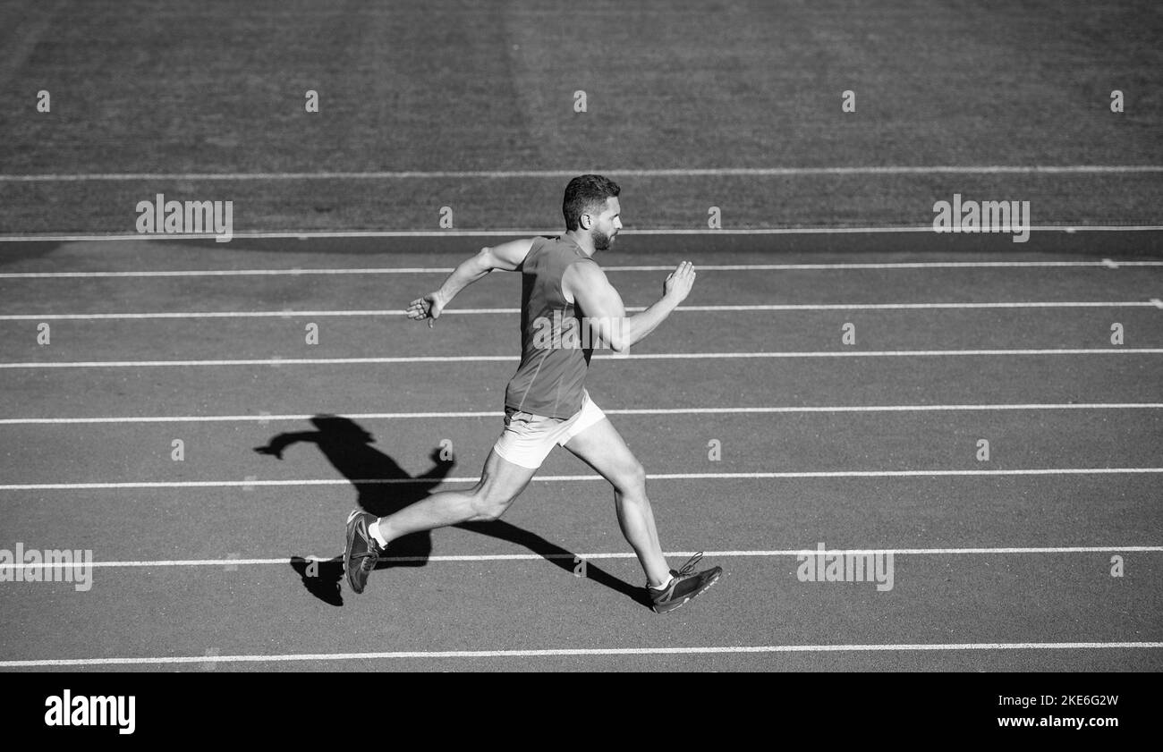 energetic athletic muscular man runner running on racetrack at outdoor ...