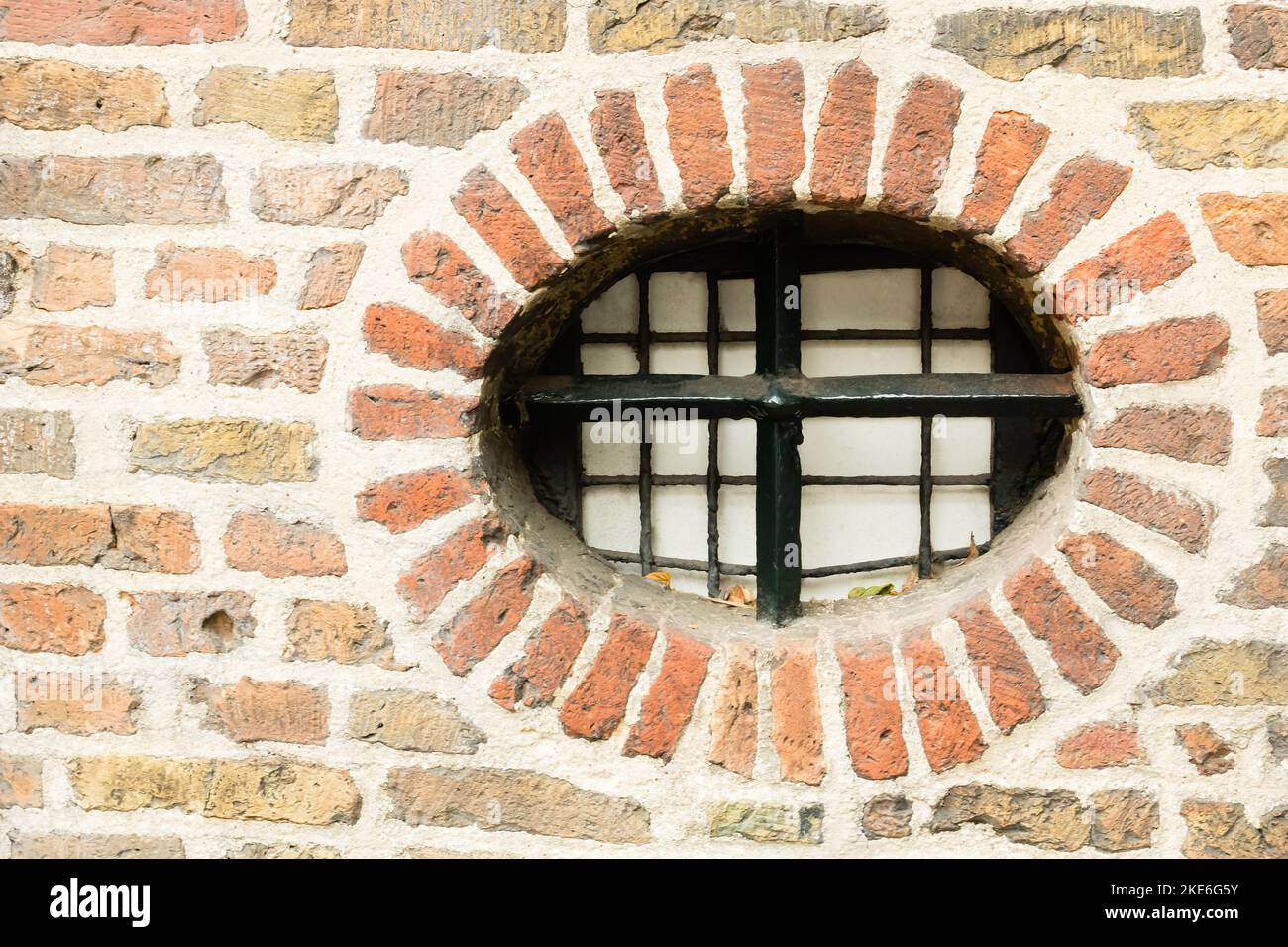 Little round window with cast iron fence in ancient brick wall, Utrecht ...