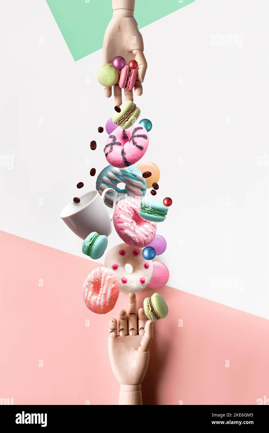 Assorted sweets and coffee between wooden model hands. Composite image ...