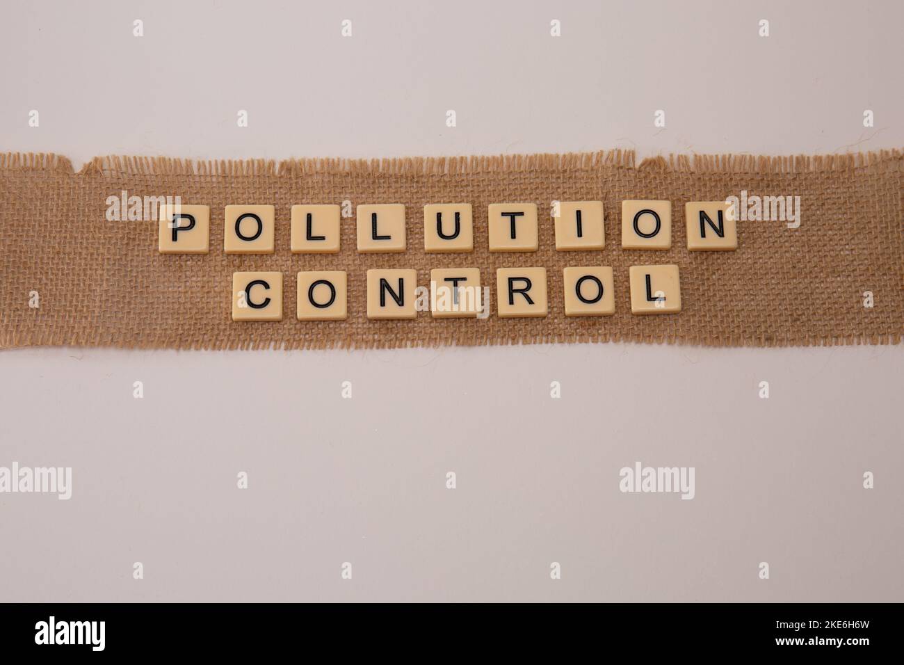 Letter tiles Pollution Control laying on jute natural sackcloth ribbon ...