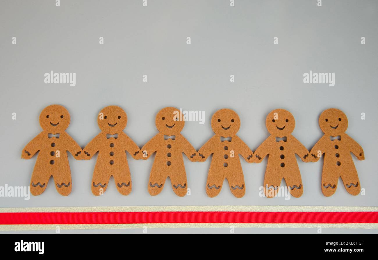 Gingerbread men in a line, red and gold ribbon Stock Photo - Alamy