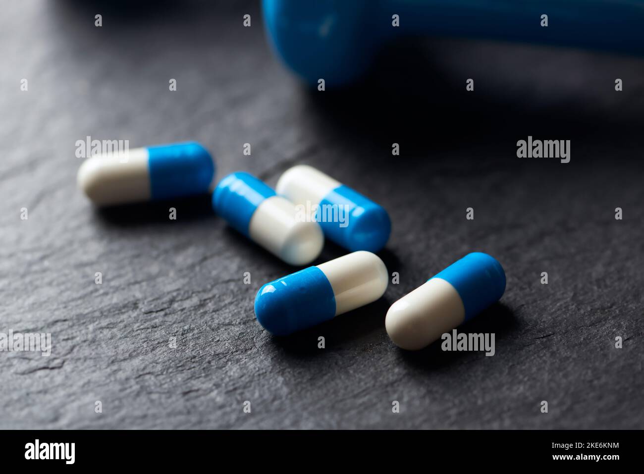 Sports Supplements (creatine capsules) on dark stone background. Close ...