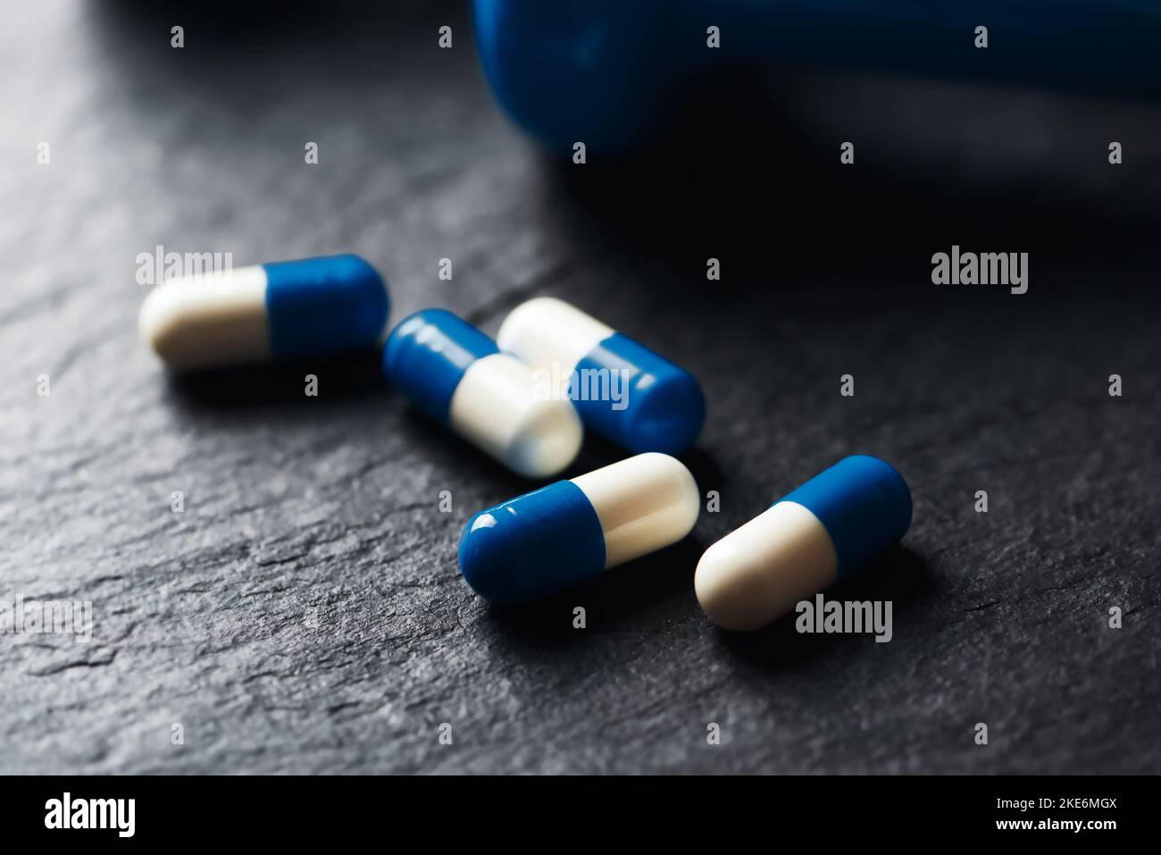 Sports Supplements (creatine capsules) on dark stone background. Close ...