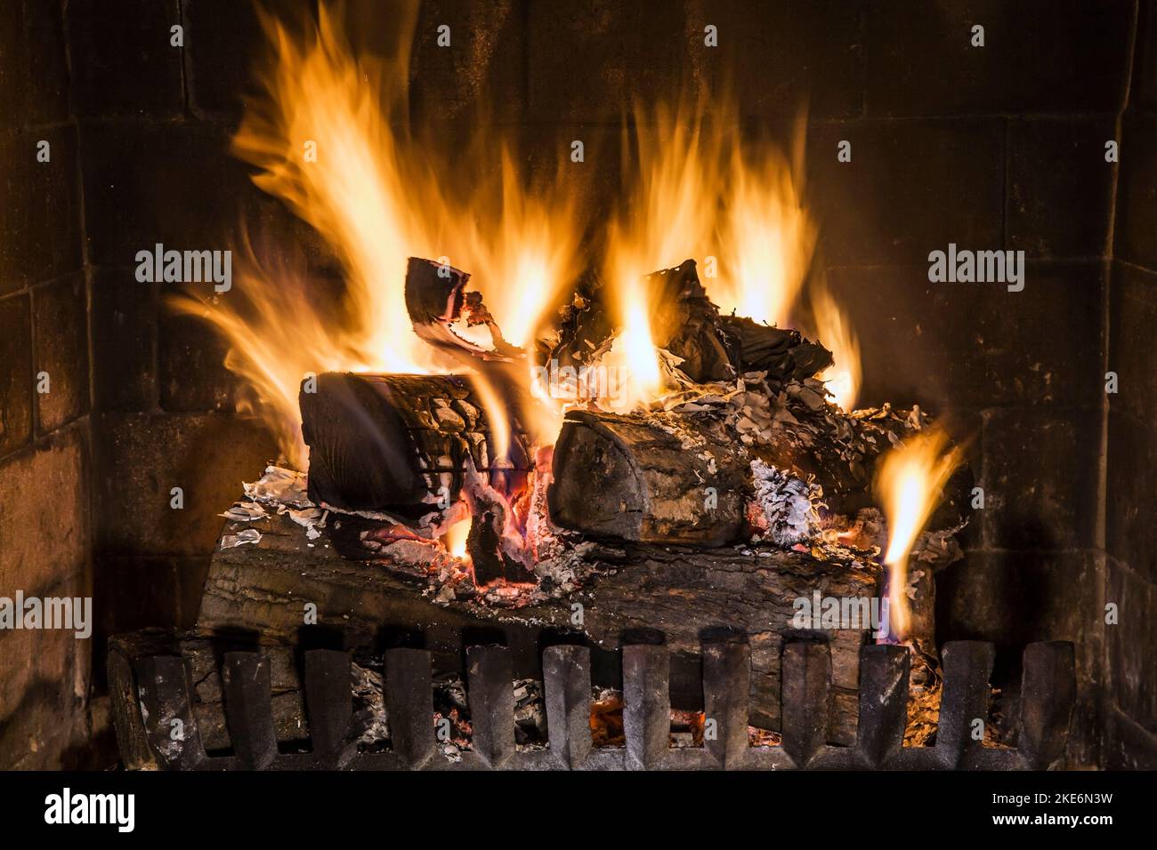 Lit wood burning fireplace in living room inside old renovated circa ...