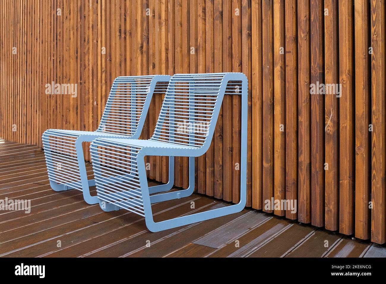 Two wet metal chairs with raindrops of modern design close-up. Urban ...