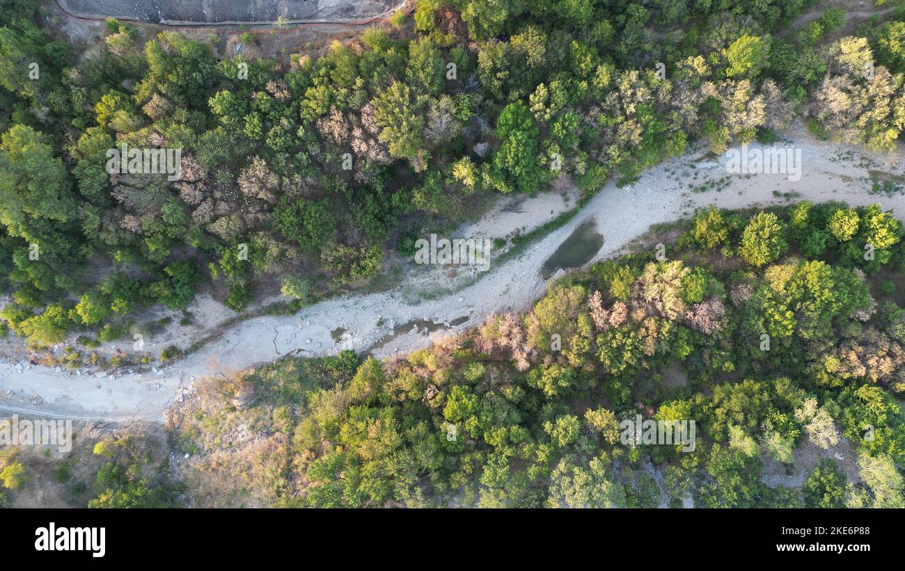 An aerial view of a dry river with sandy bed and banks, with slightly ...