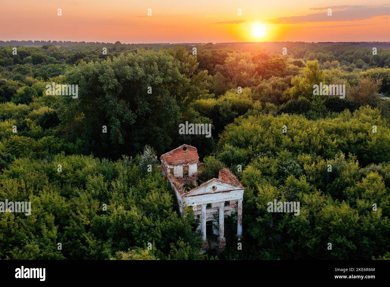 Old ruins of abandoned mansion overgrown by plants, aerial view. Former ...