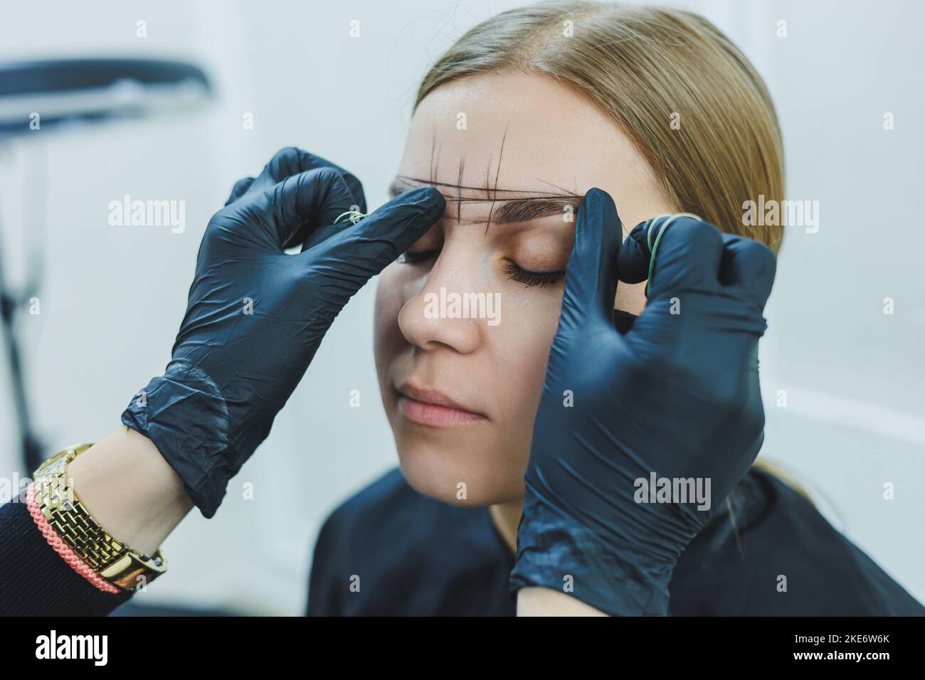Young woman during professional eyebrow mapping procedure before ...