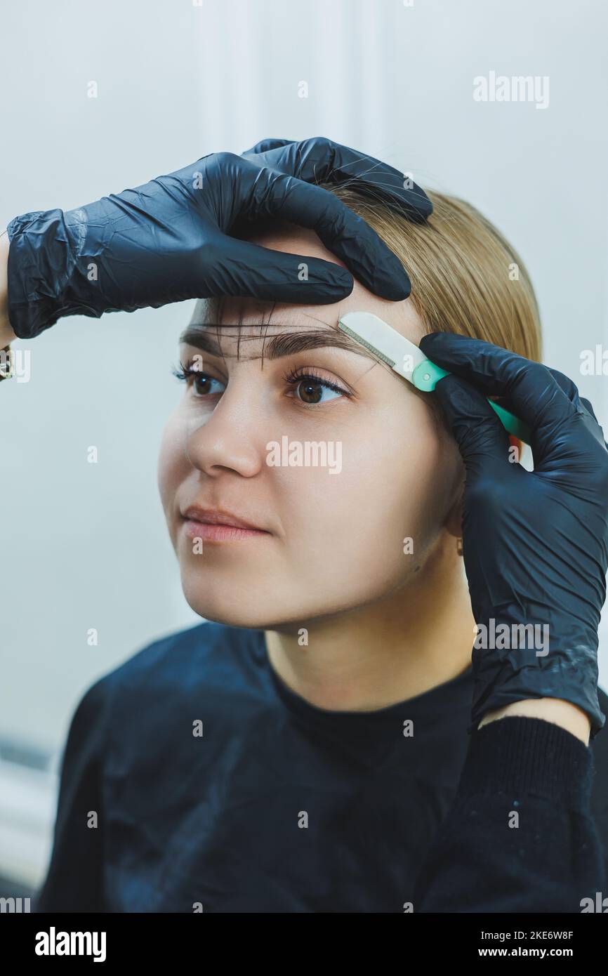 permanent eyebrows tattoo. permanent tattoo master checks the distance ...