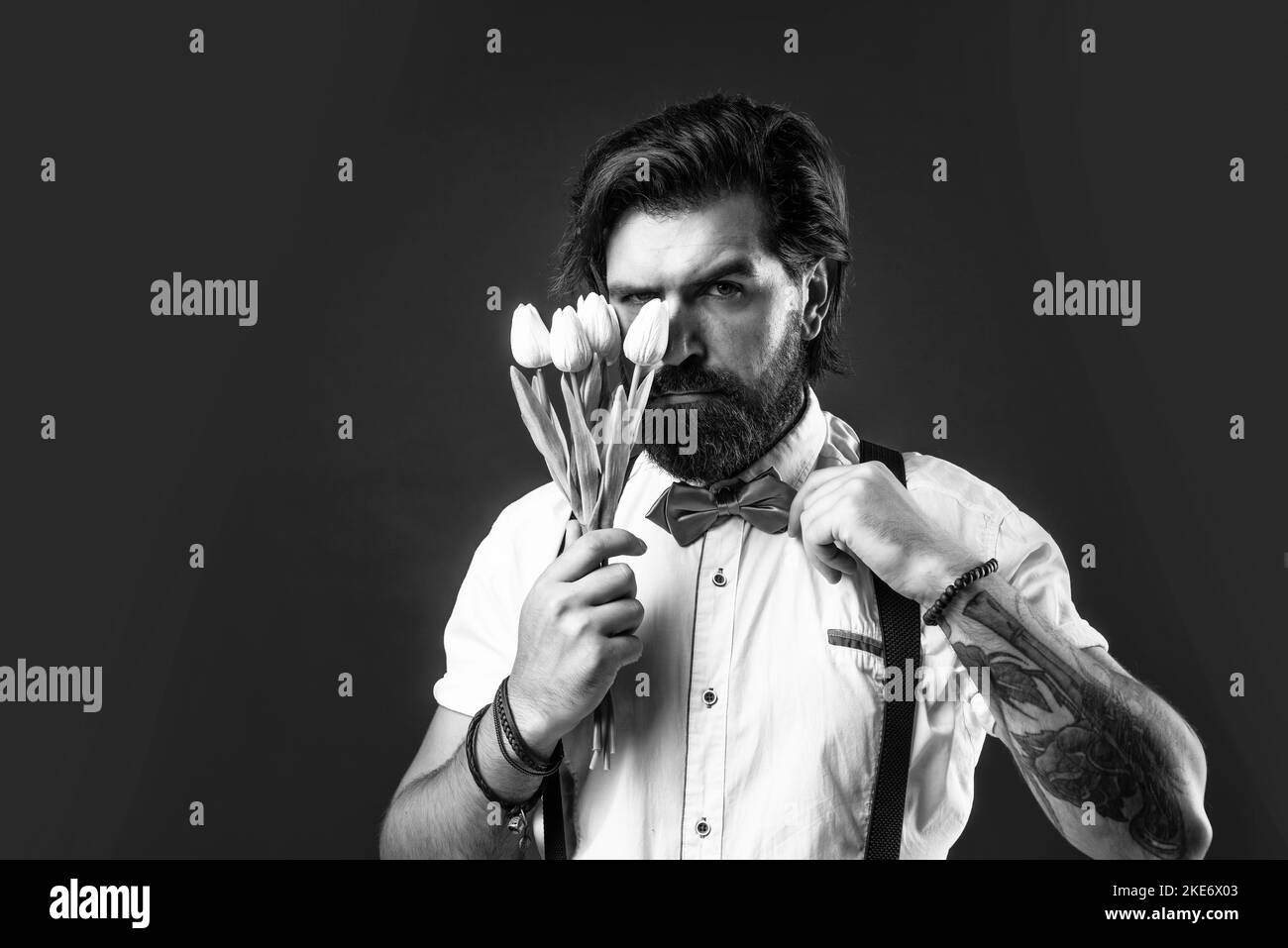 brutal bearded male with stylish look hold tulip bouquet, mothers day ...