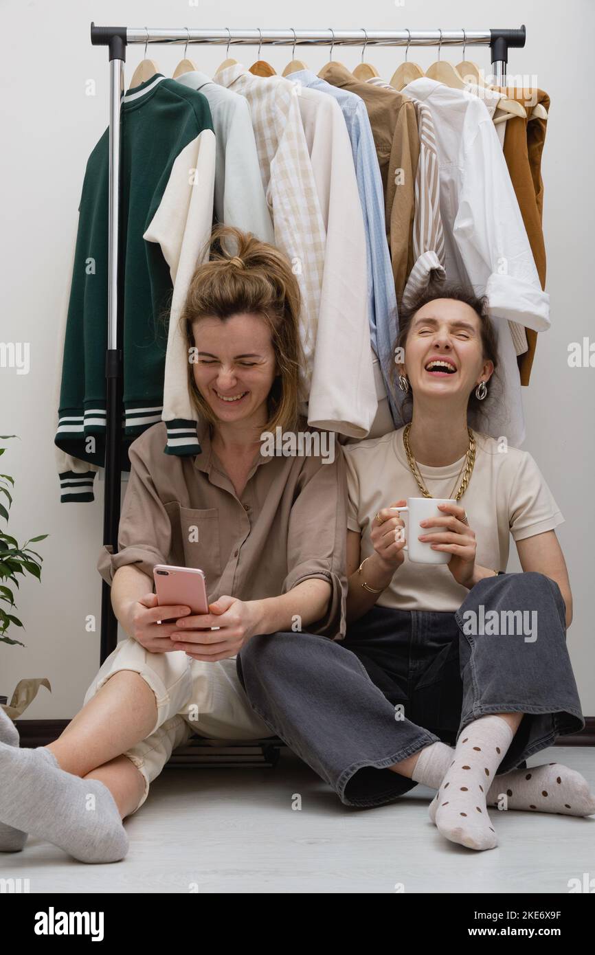 Wardrobe organization concept - two female friends laughing near ...