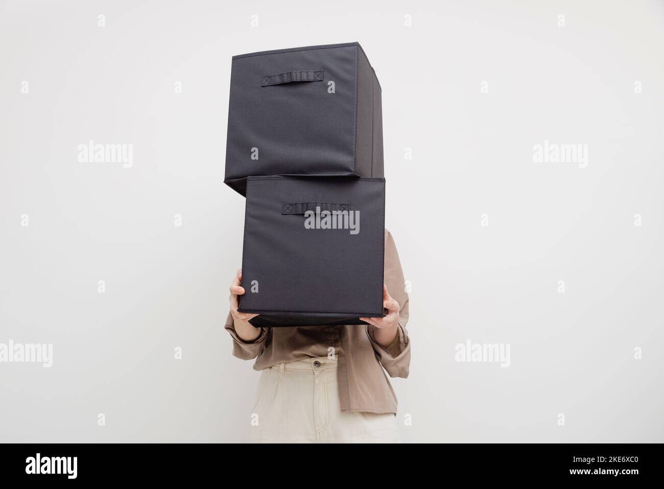 Woman holding boxes for closet organization or moving house. Faceless ...