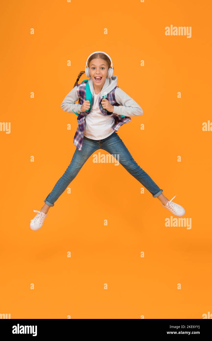 Energetic and enthusiastic. Energized small girl jump high with ...