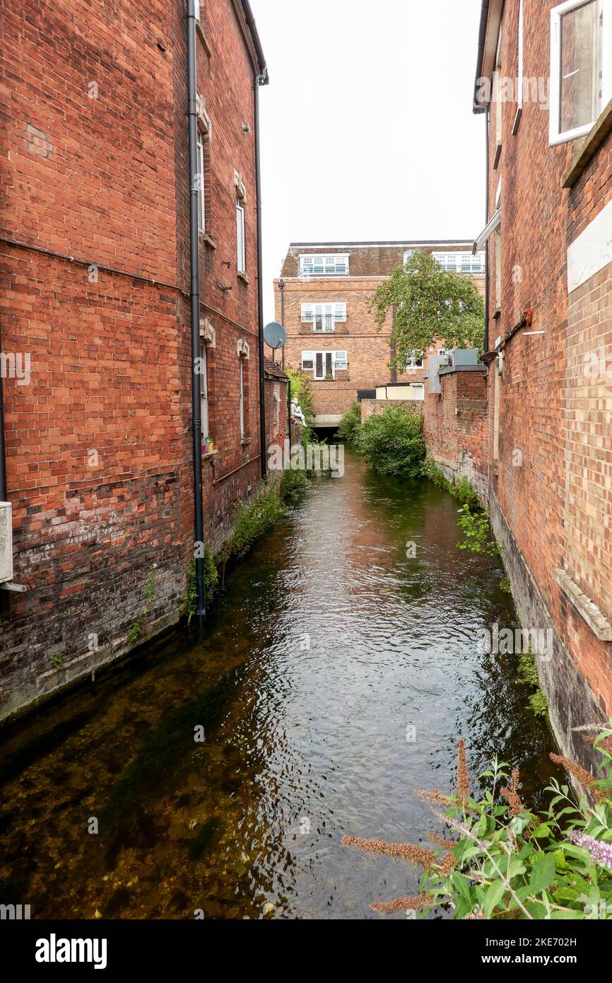 River running between red brick buildings Stock Photo - Alamy
