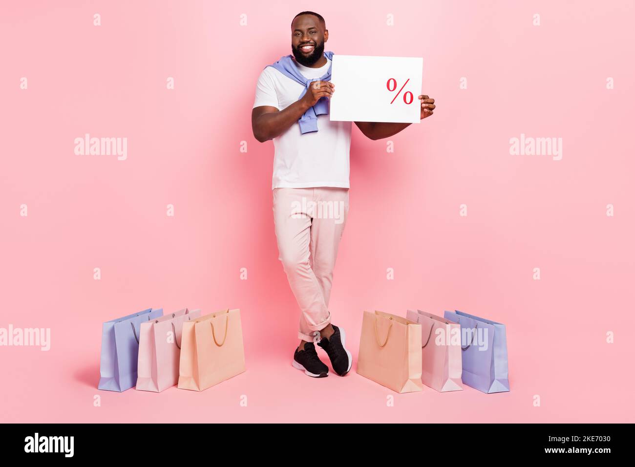 Full size photo of cheery young man shopaholic show black friday ...