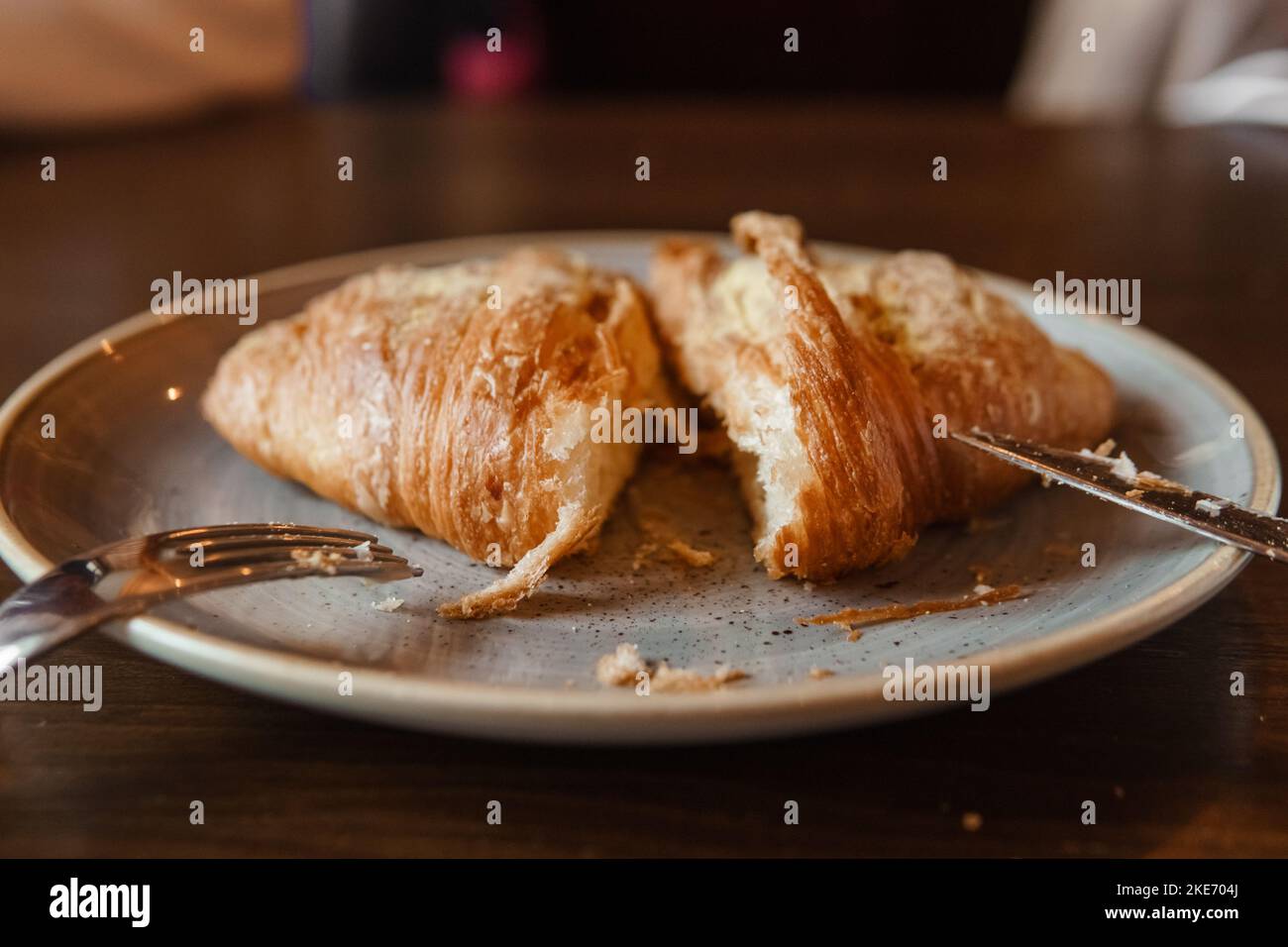 Cutting a croissant on a plate, close-up Stock Photo - Alamy