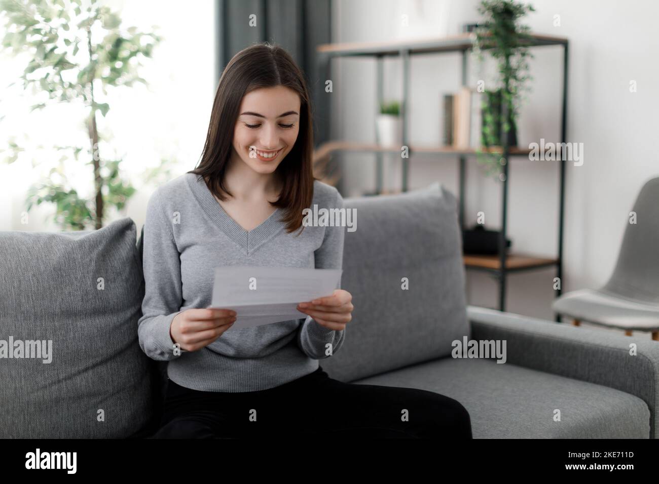 Woman reading letter on sofa hi-res stock photography and images - Alamy