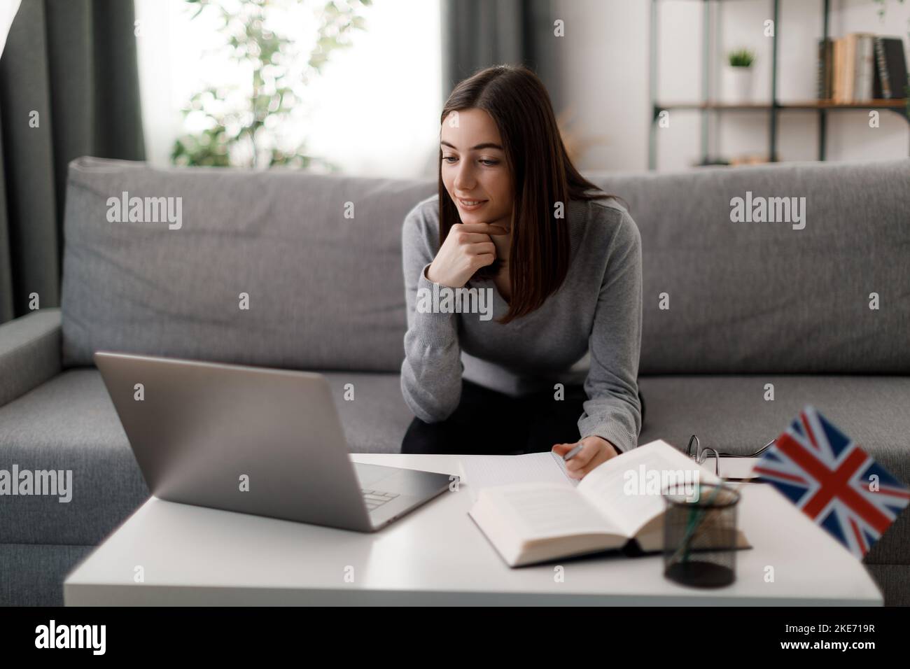 Woman with laptop studying english Stock Photo - Alamy