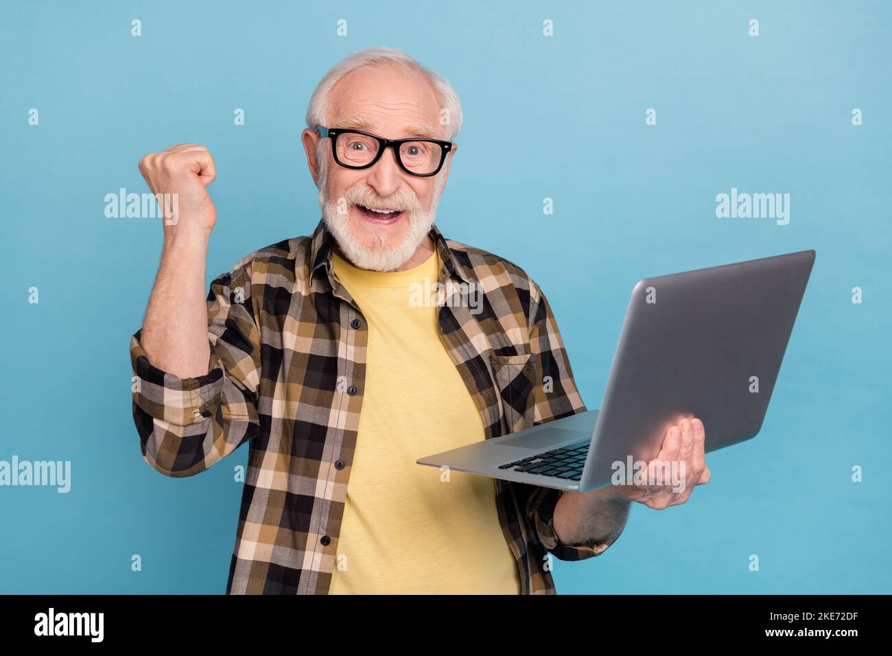 Photo of cute lucky retired man wear plaid shirt spectacles rising fist ...