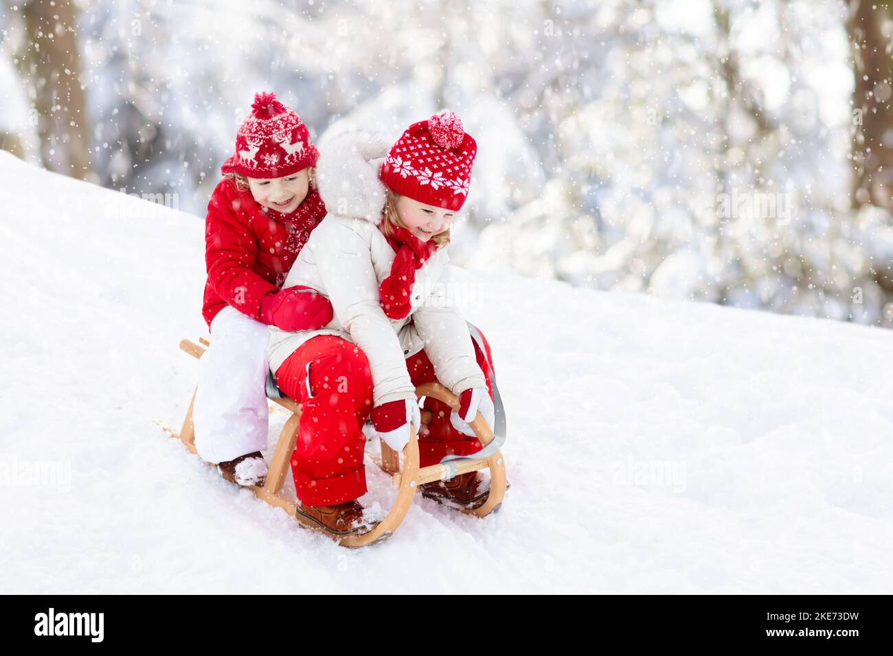 Little girl and boy enjoy a sleigh ride. Child sledding. Toddler kid ...