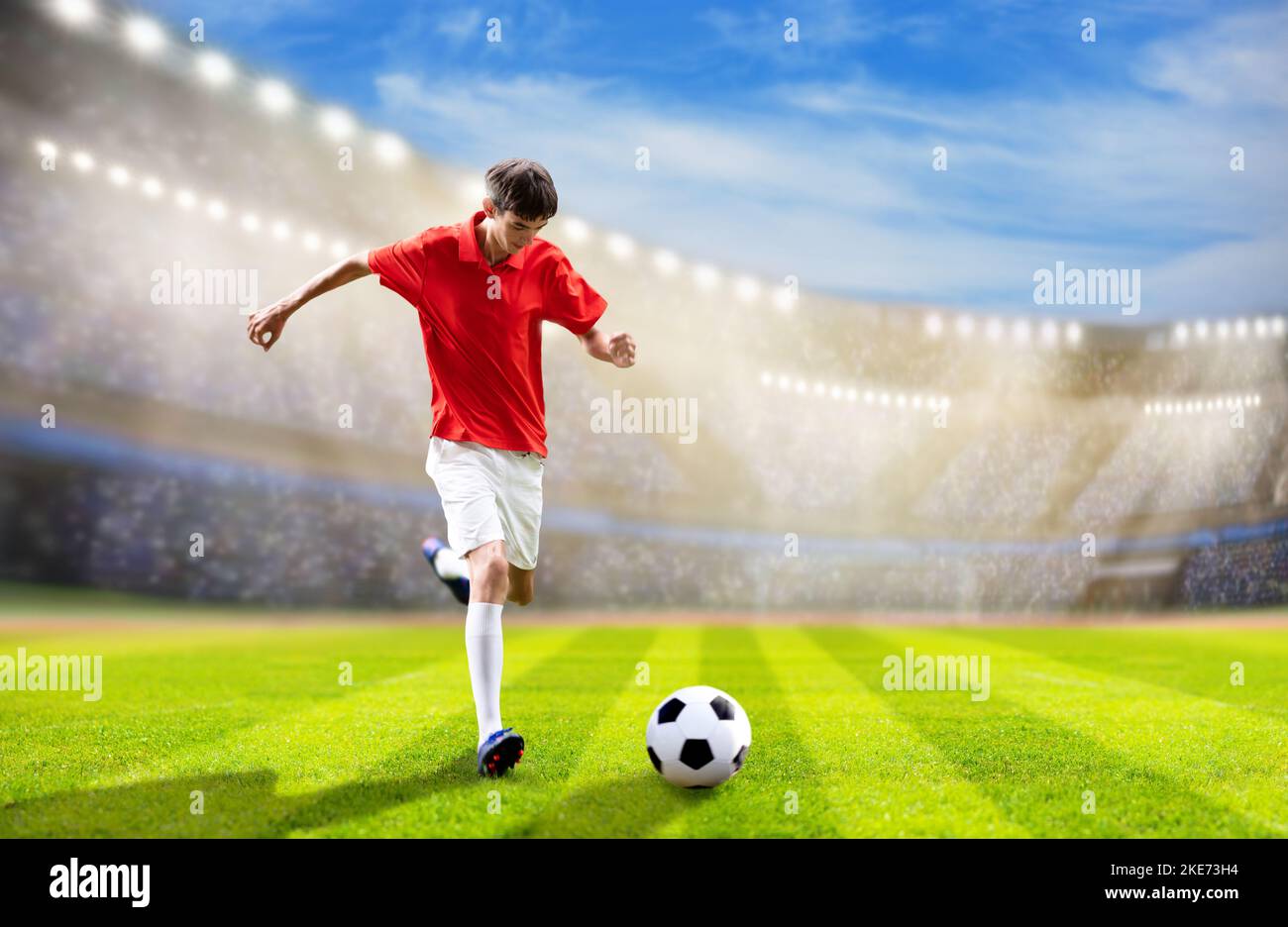 Football player on stadium field. Soccer match. Young man in red shirt ...