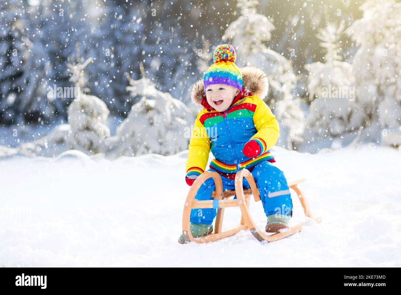 Little boy enjoying a sleigh ride. Child sledding. Toddler kid riding a ...