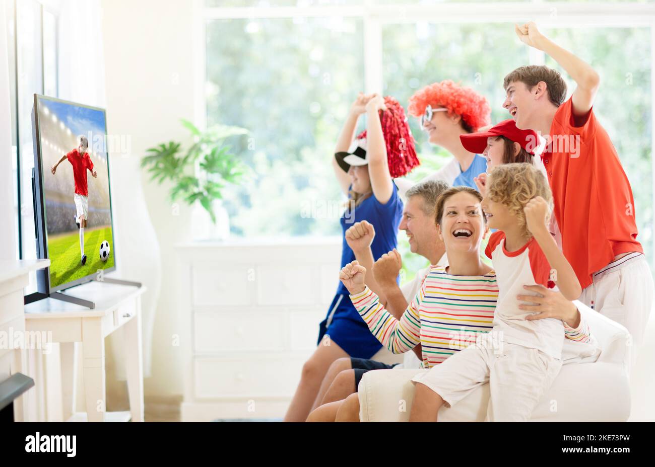 Group of football fans watch tv at home. Friends watching soccer match ...