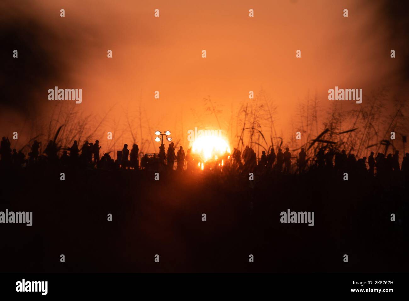 The sun is rising behind the silhouette of people during golden hour ...