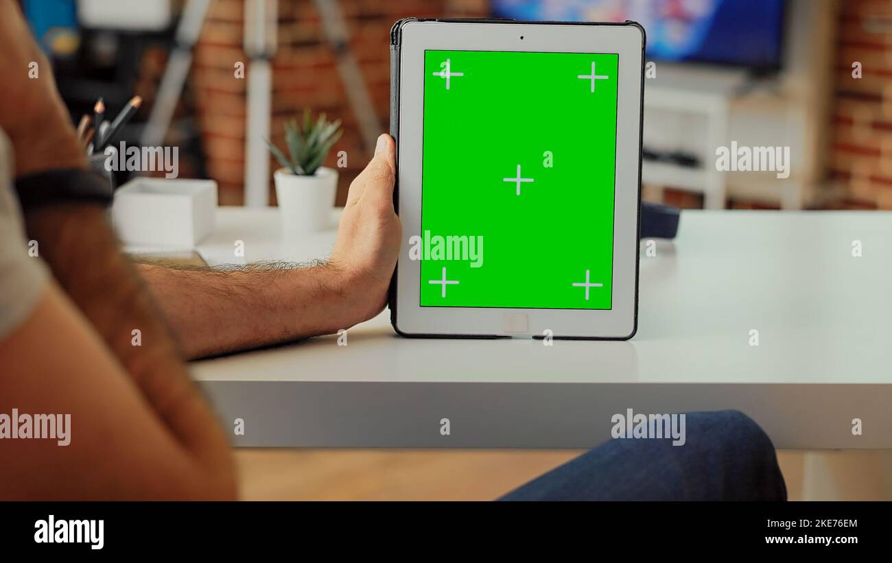 Office employee holding digital gadget showing greenscreen template ...