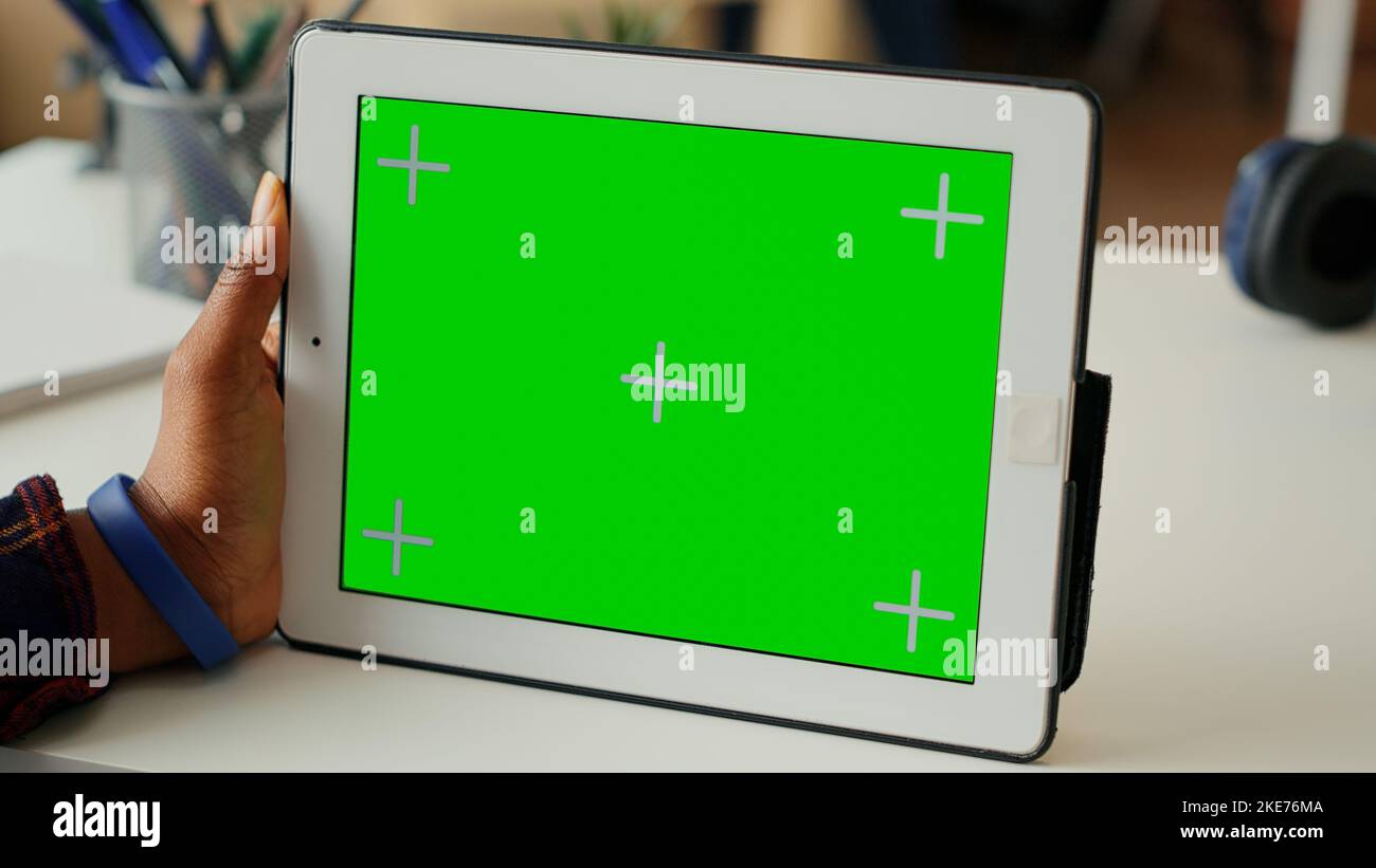 Modern person looking at horizontal greenscreen display on tablet at ...