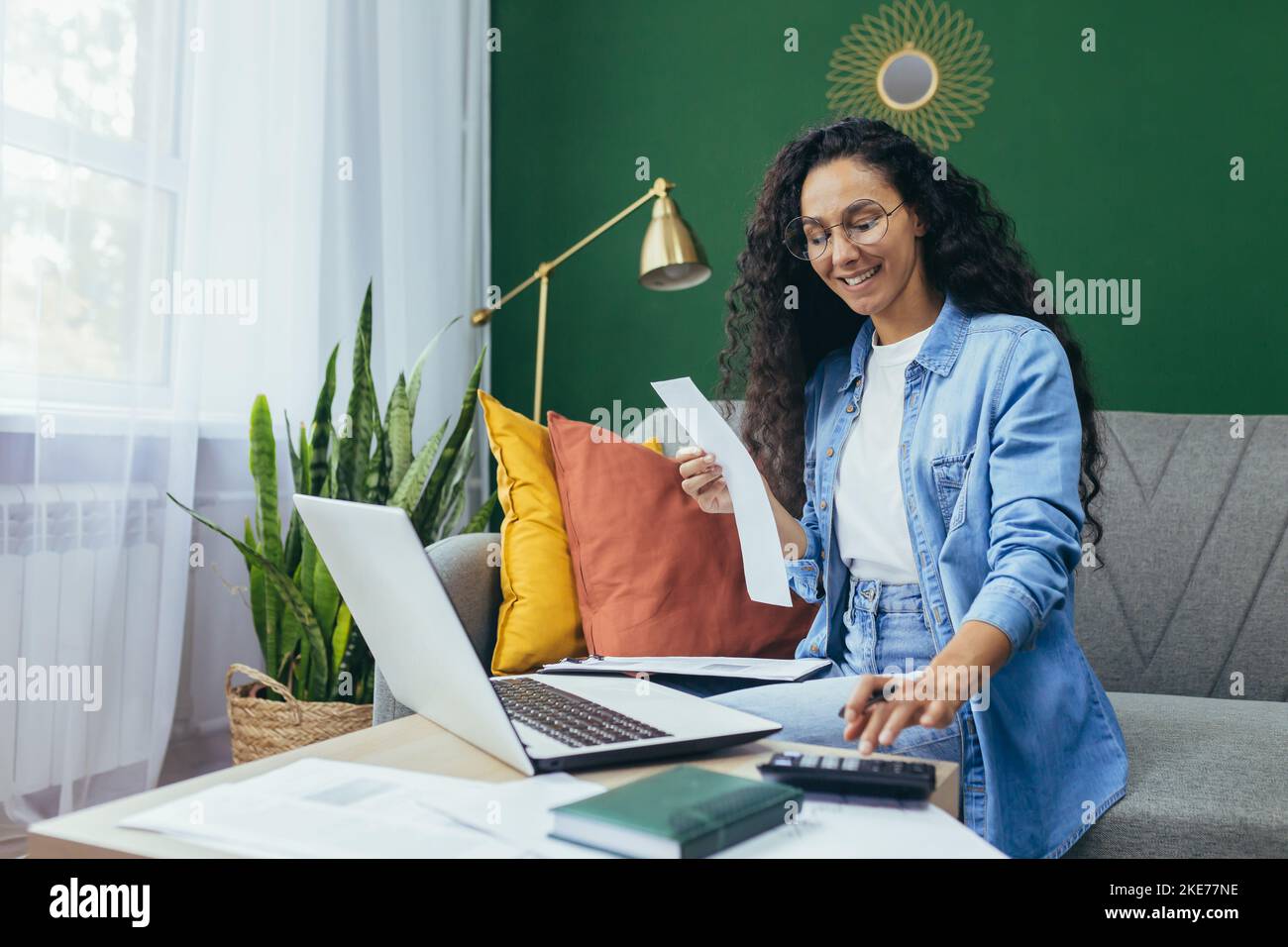 Happy hispanic woman at home doing paperwork business woman calculating ...