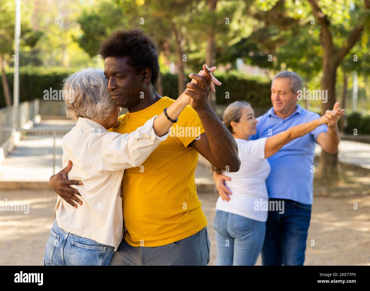 Cheerful multiracial middle aged and older adults enjoying dancing in ...