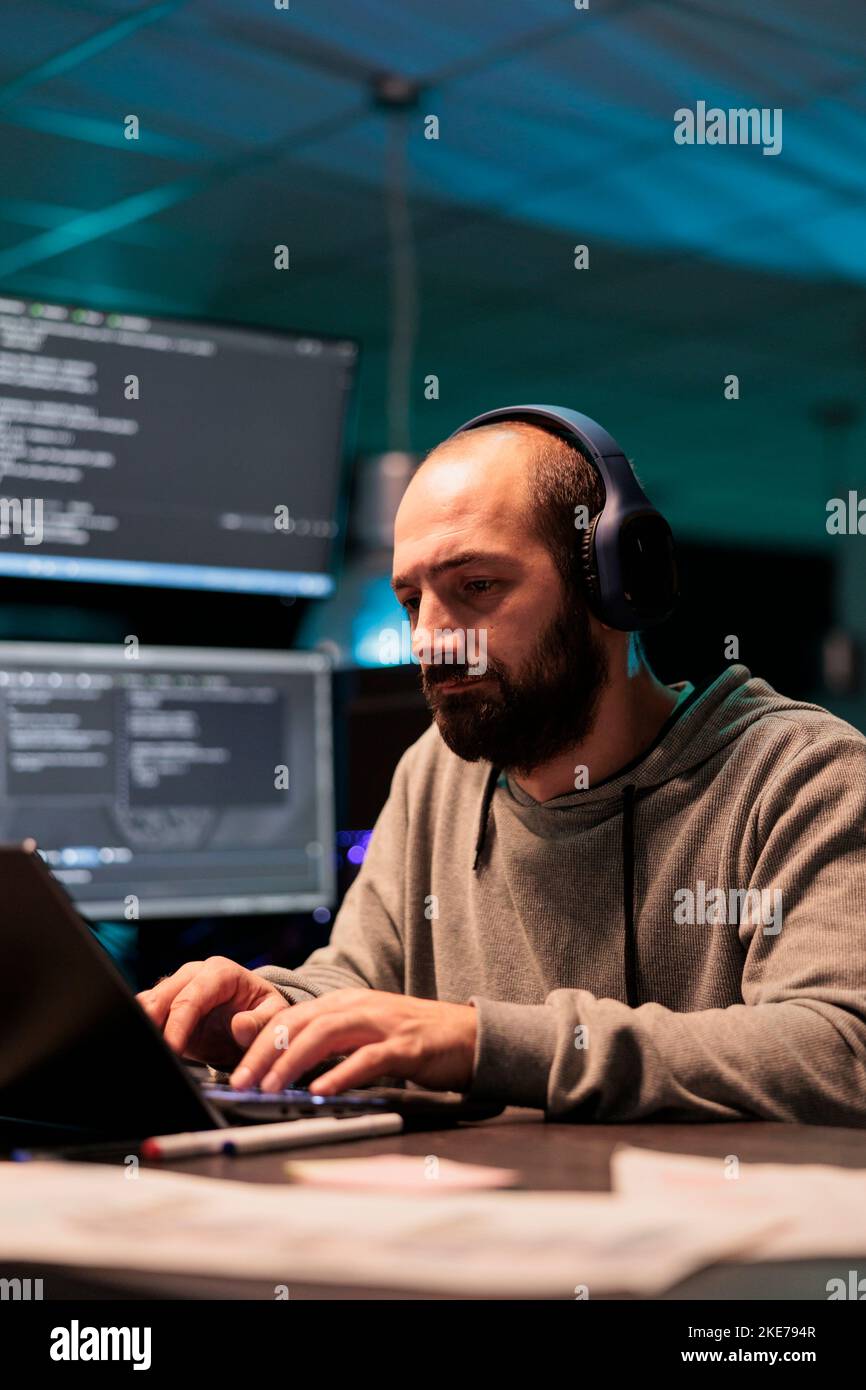 Young App Developer Writing Code And Listening To Music On Headphones Using Artificial