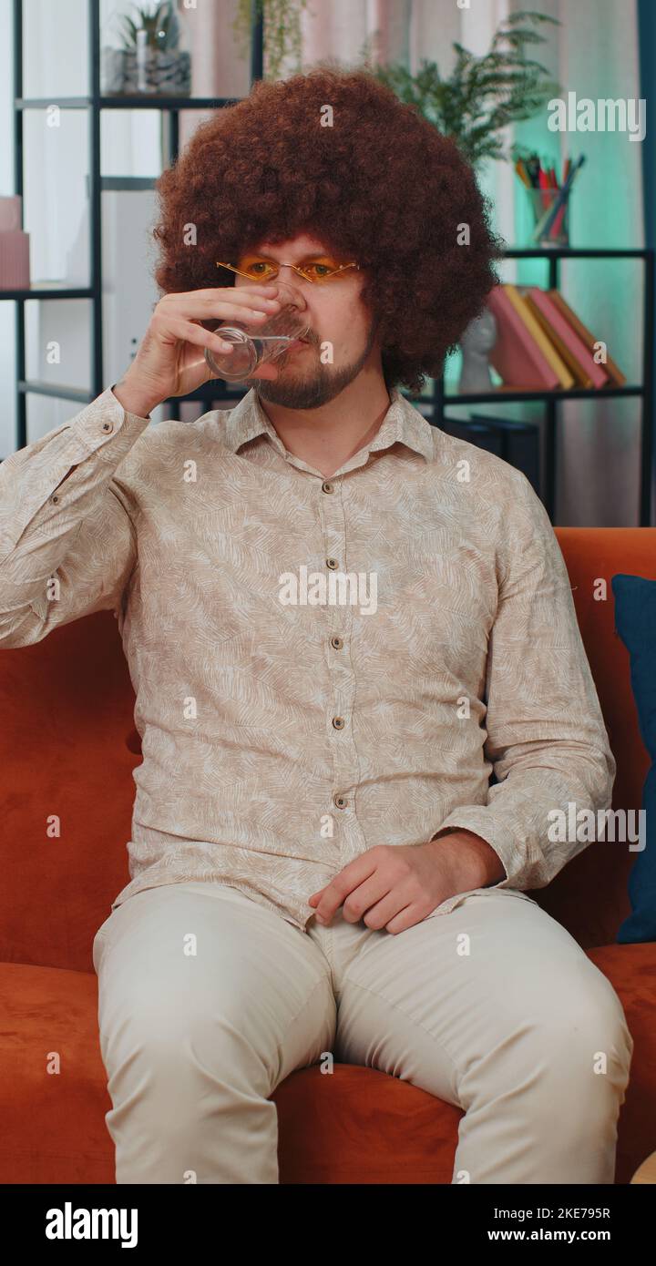 Thirsty man holding glass of natural aqua make sips drinking still ...