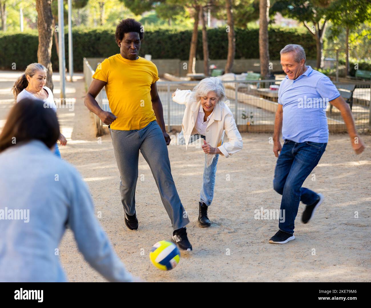 Cheerful group of mixed-race middle-aged and older adult people playing ...