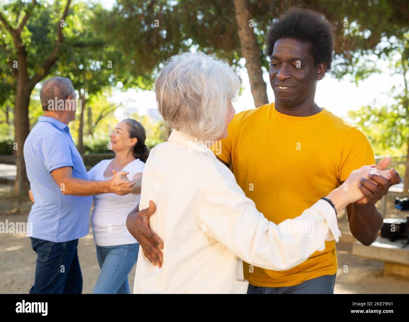 Exited older and middle-aged diverse people enjoying latin dances ...