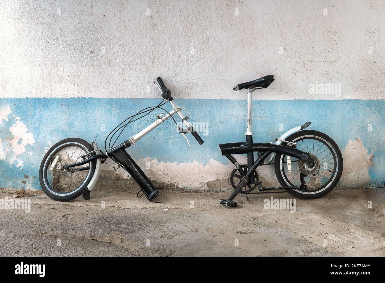 Old bicycle with a frame broken in half stands against the wall Stock ...