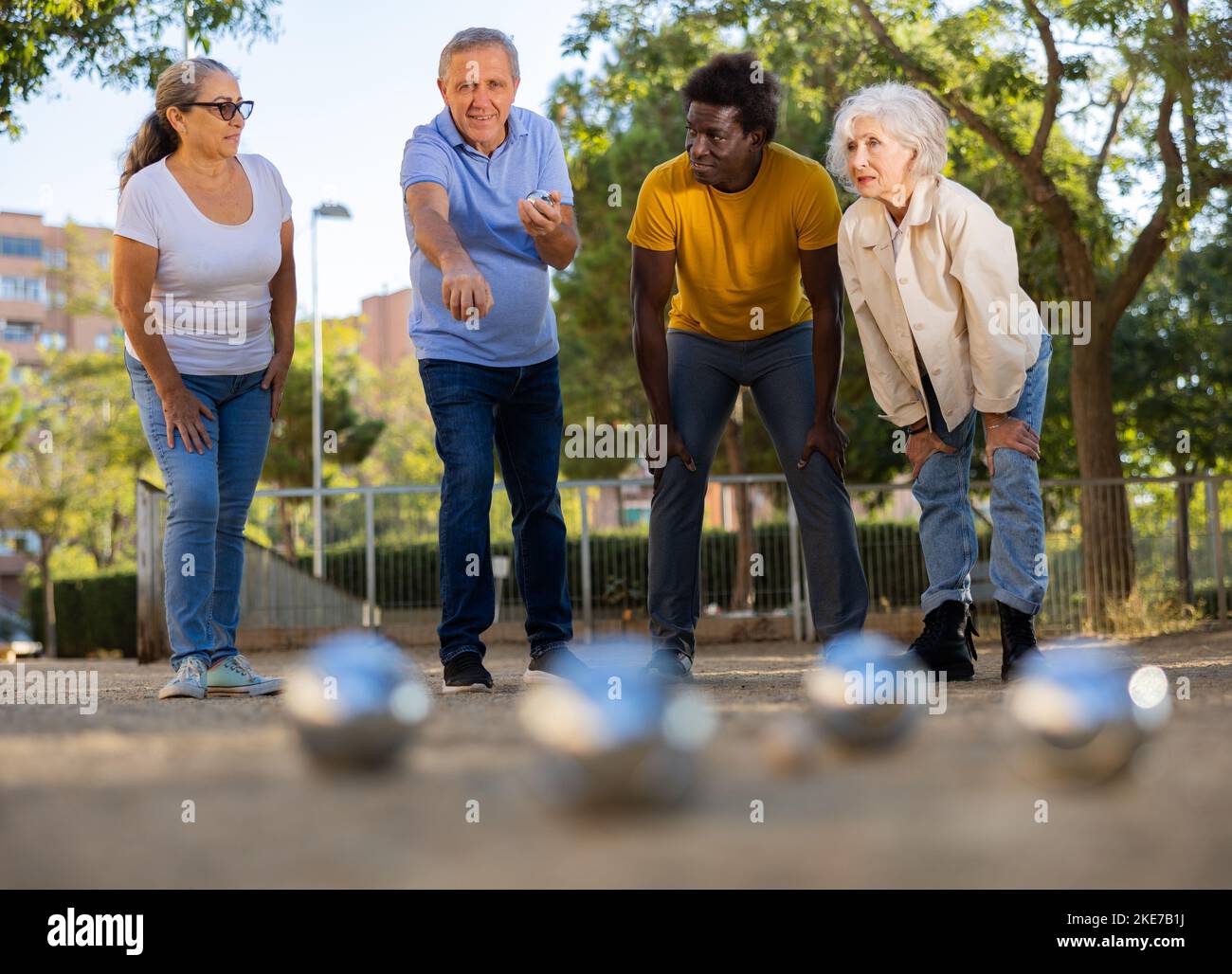 A group of multiracial mature adult people playing patanque game ...