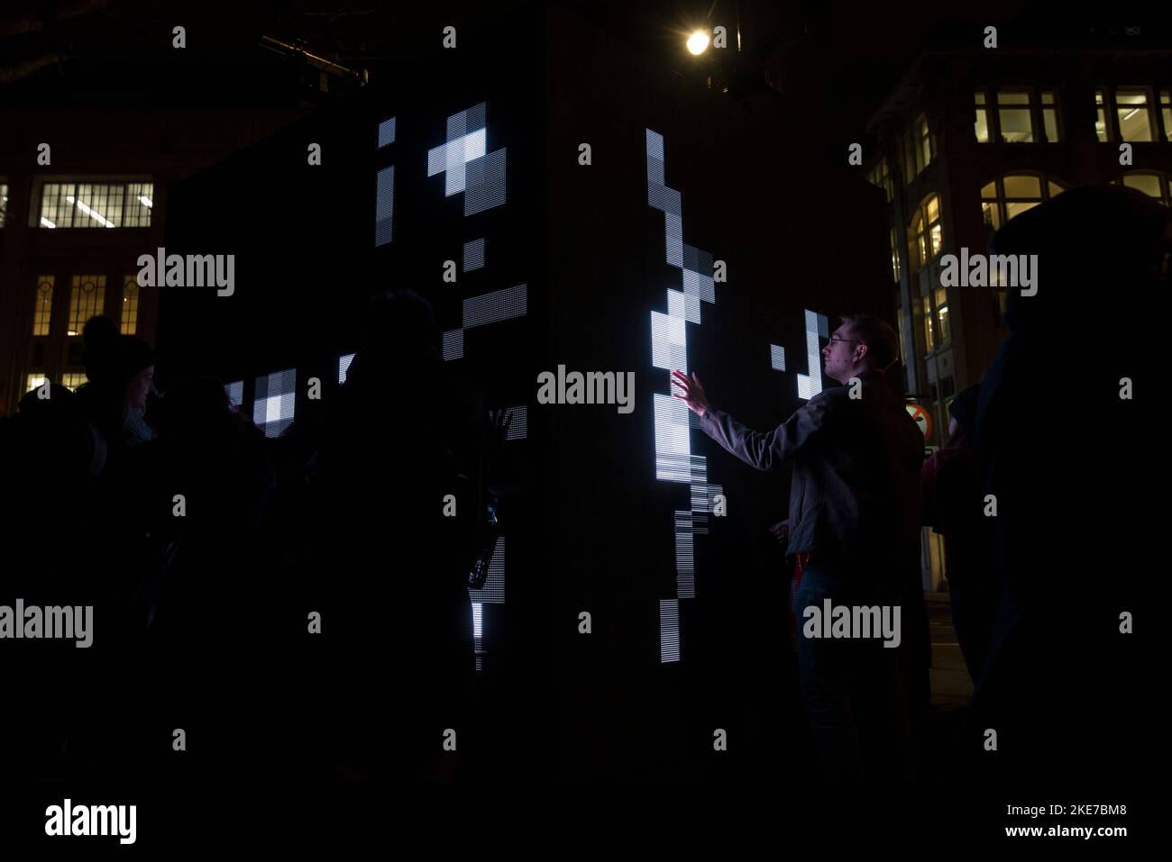 People touching an interactive light exhibit Stock Photo - Alamy